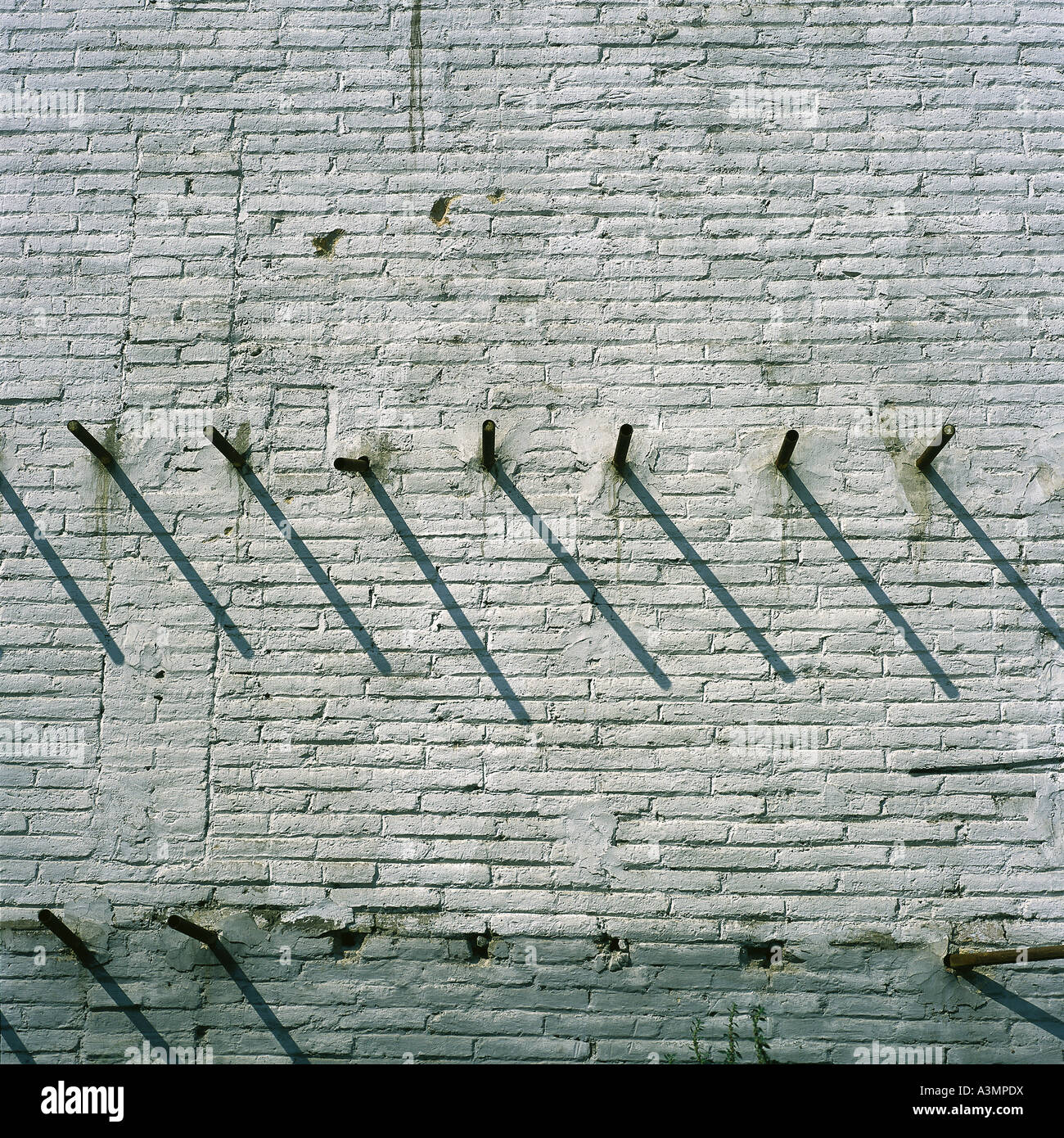 brick wall with a row of steel bars protruding Stock Photo - Alamy