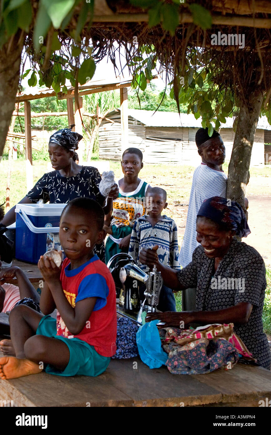 Ghanaian woman seamstress and family using hand operated sewing machine ...