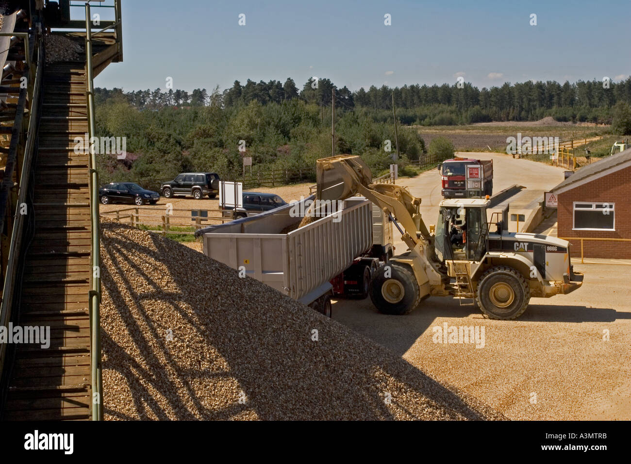 Loading gravel into truck from stockpile at quarry for construction ...