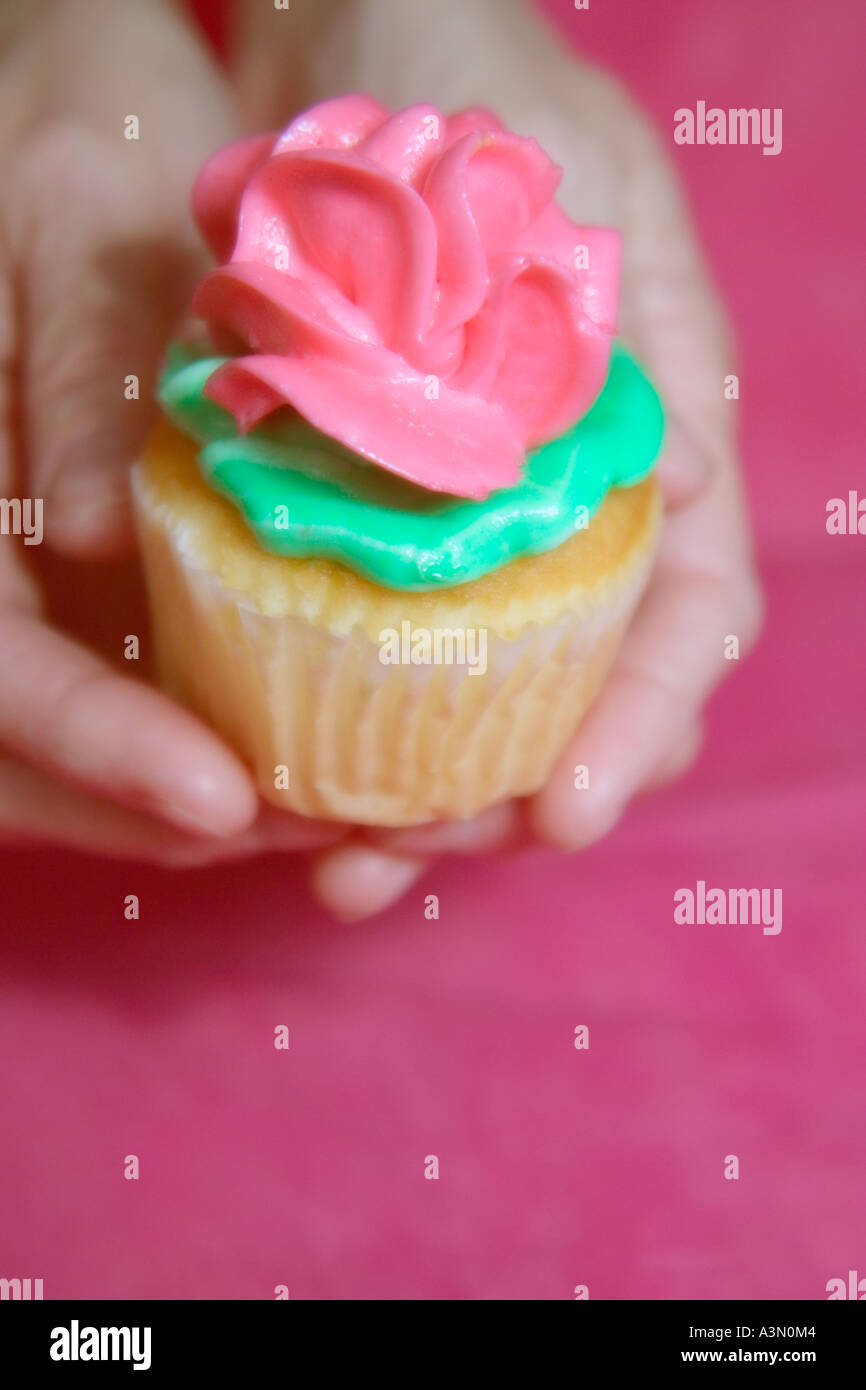 Two hands giving cupcake Stock Photo - Alamy