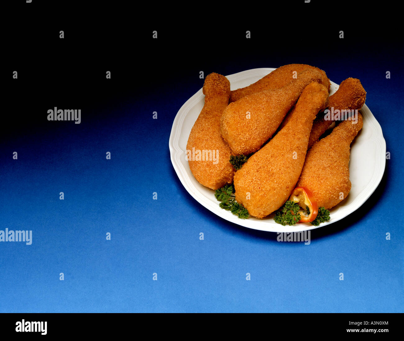 breaded turkey legs platter blue background white plate Stock Photo - Alamy