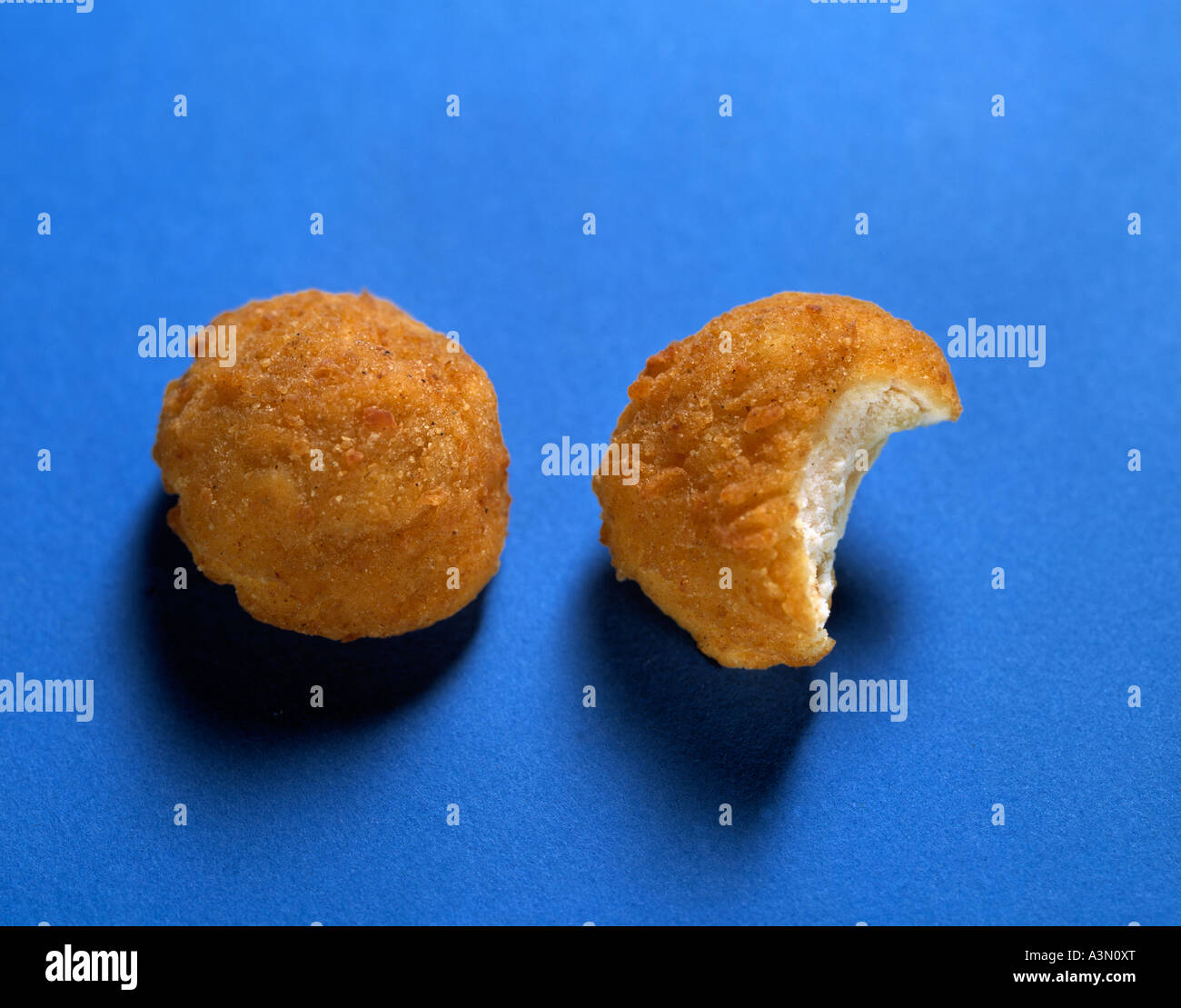 bite size chicken nugget pieces blue background Stock Photo - Alamy