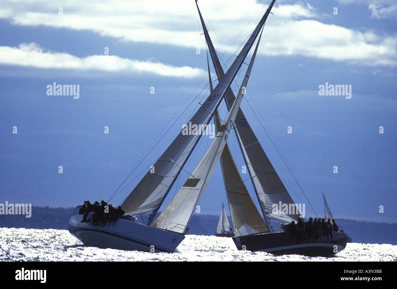 Two IMS racing yachts silhouette cross tack on a silver sea shot into ...