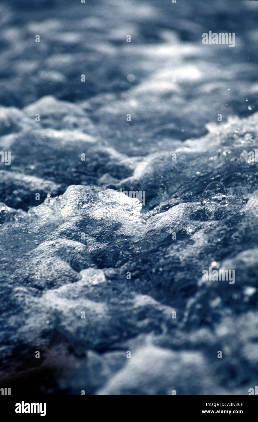 Detail of water texture with ripples and bubbles on the river surface ...