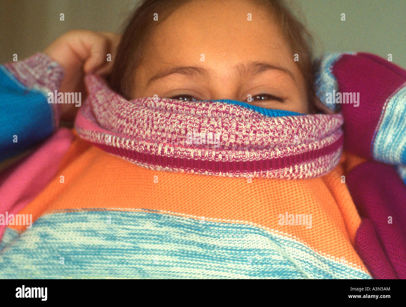 Pretty young girl smiling taking her sweater off over her head Stock ...