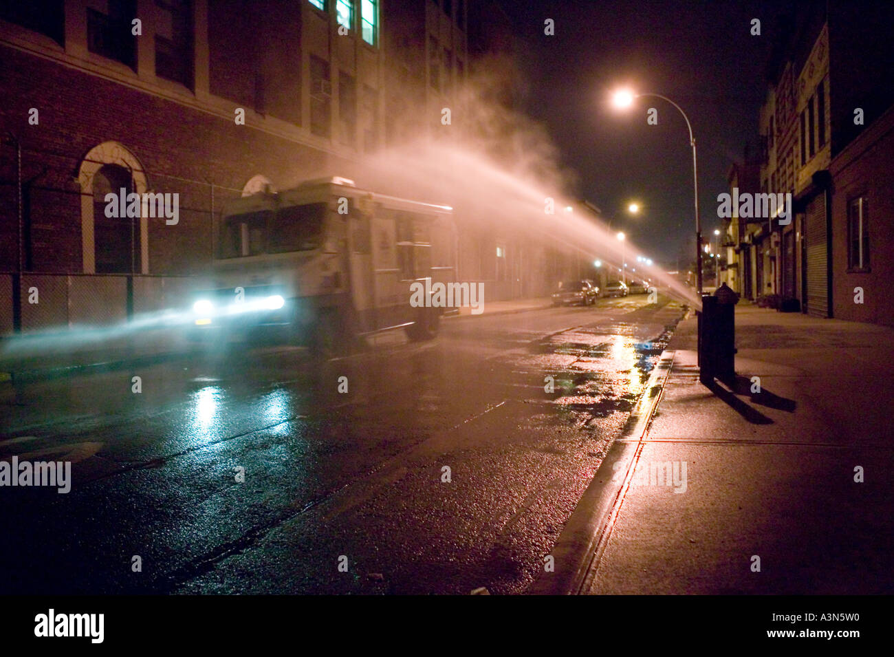 A delivery truck passes under the spray of an open fire hydrant in a ...