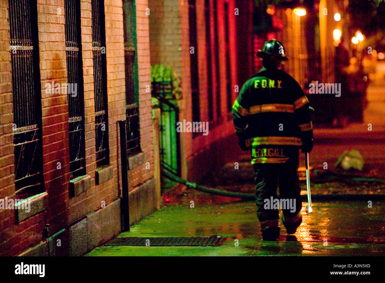 Firefighter walks past an appartment building on fire in Harlem New ...