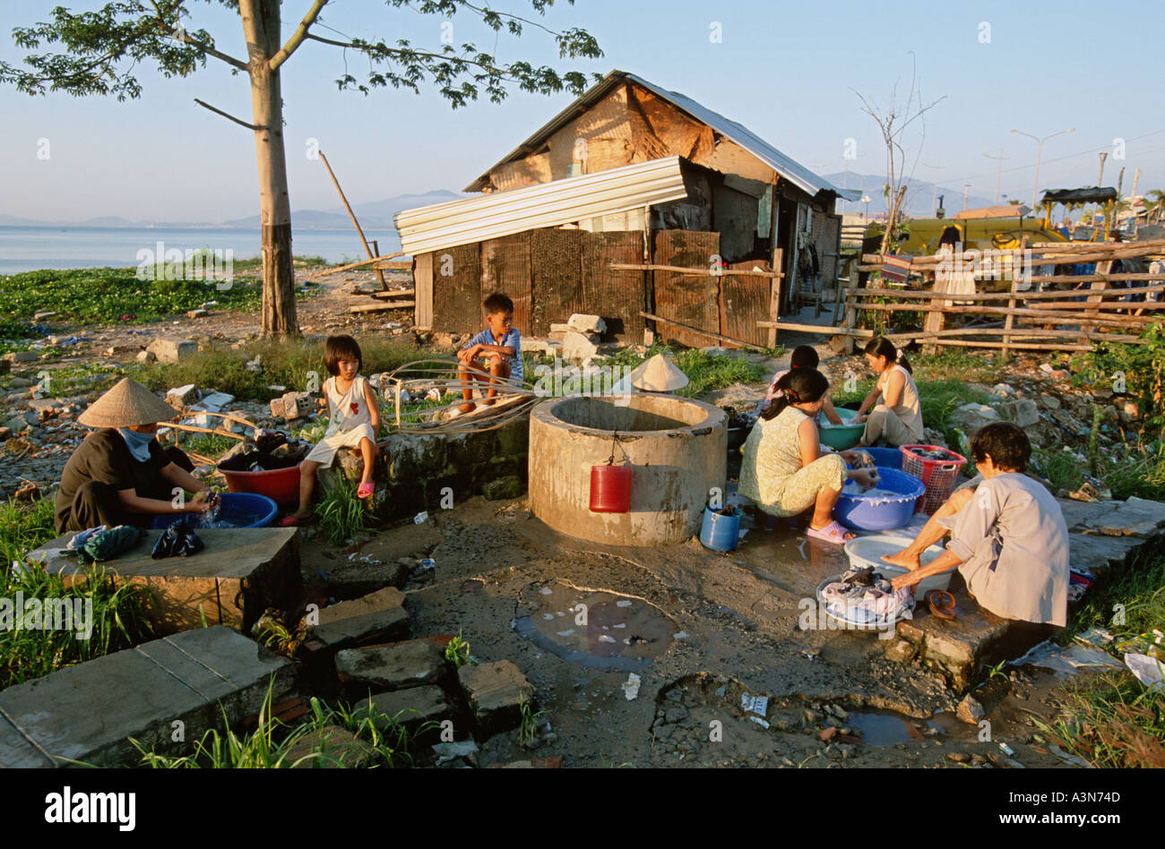 Poor family collecting water from communal well in city of Nha Trang ...