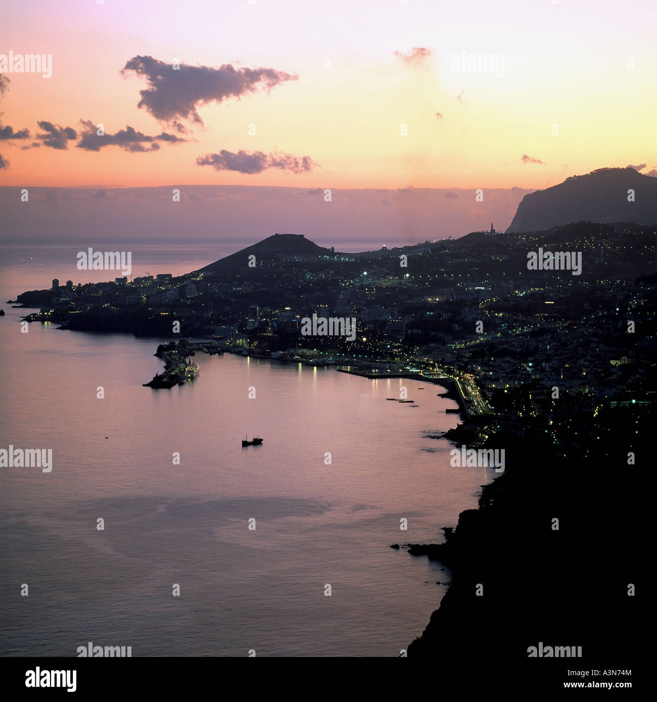 FUNCHAL TOWN SKYLINE WITH HARBOUR AND SEA COASTLINE AERIAL AT DUSK ...
