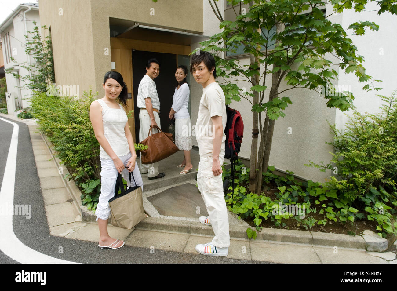 A family coming home from a trip Stock Photo - Alamy