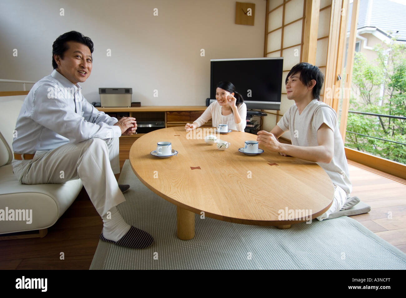 Family relaxing in living room Stock Photo - Alamy