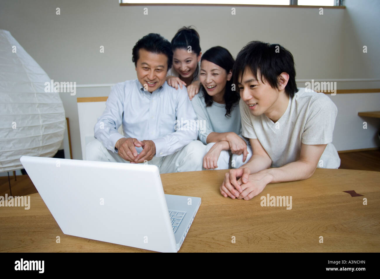 Family looking at computer Stock Photo - Alamy