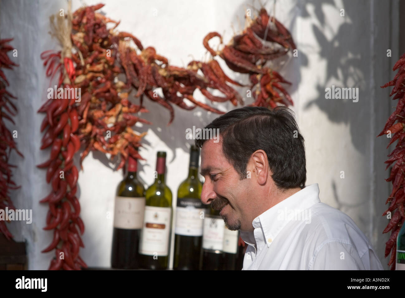Man, chilli peppers and wine bottles, in Puglia, Italy Stock Photo - Alamy