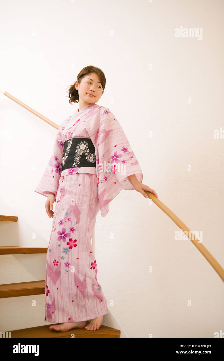 A young woman wearing yukata standing on staircase Stock Photo - Alamy