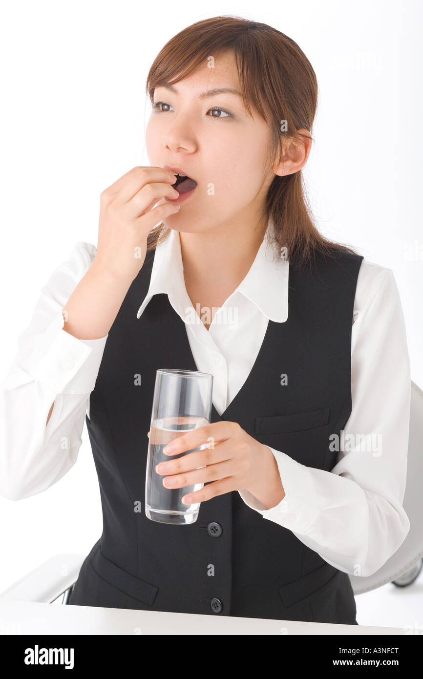 A young woman taking pills Stock Photo - Alamy
