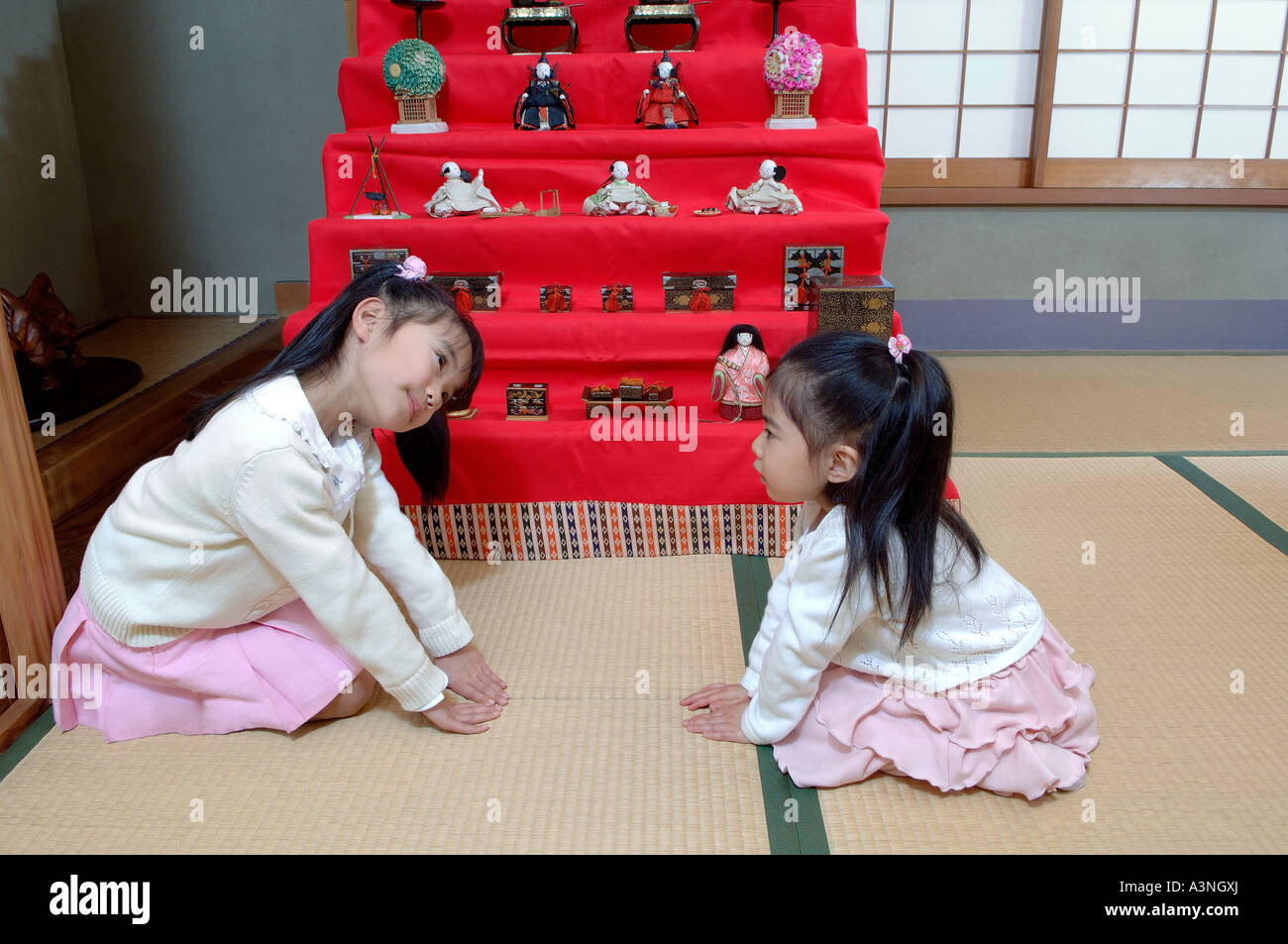 Girls bowing in front of dolls Stock Photo - Alamy