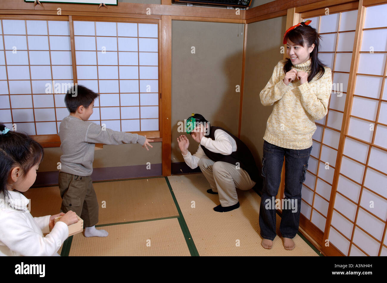 Children throwing roasted beans for setsubun festival Stock Photo - Alamy