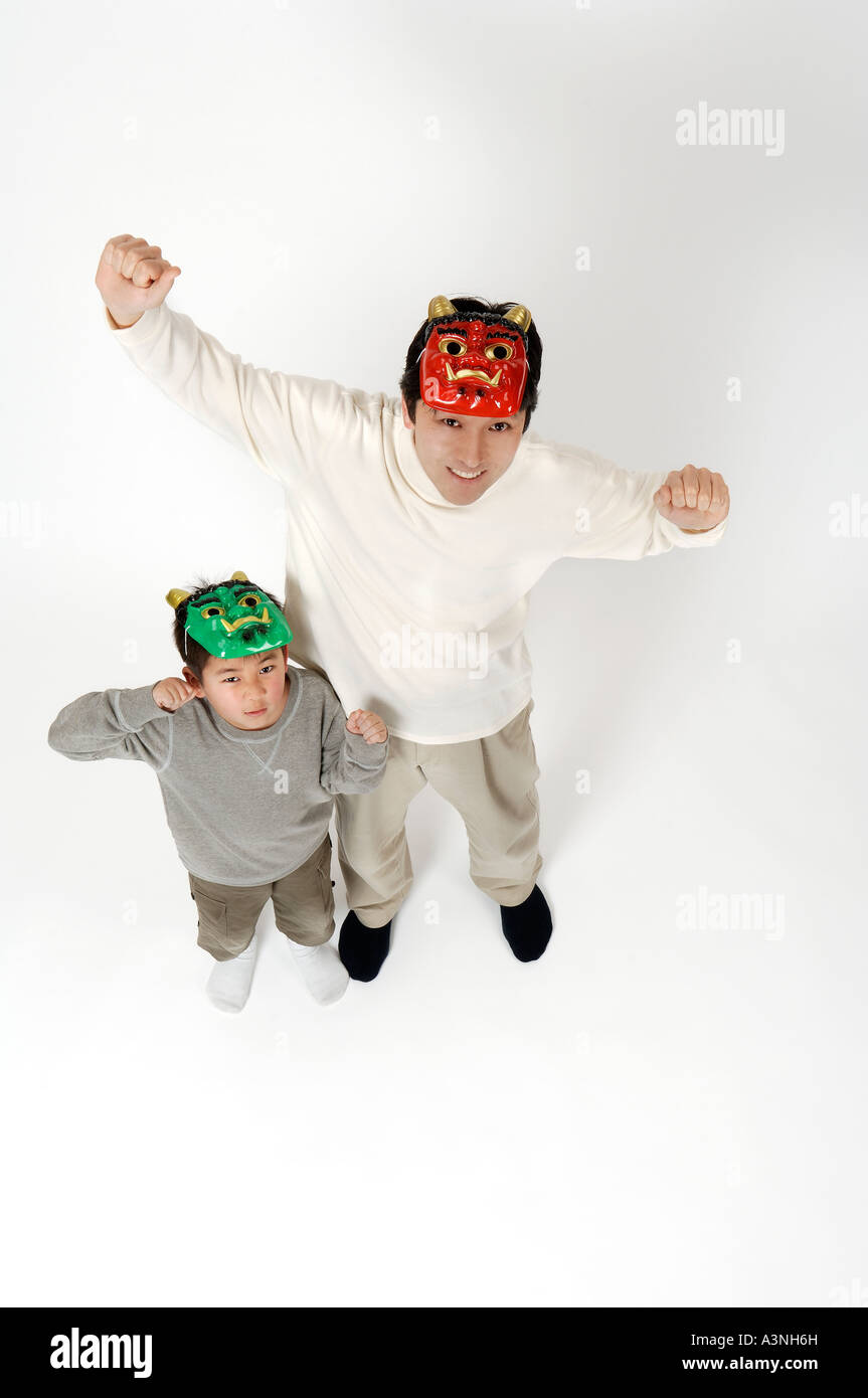 Father and son wearing mask of evil Stock Photo - Alamy