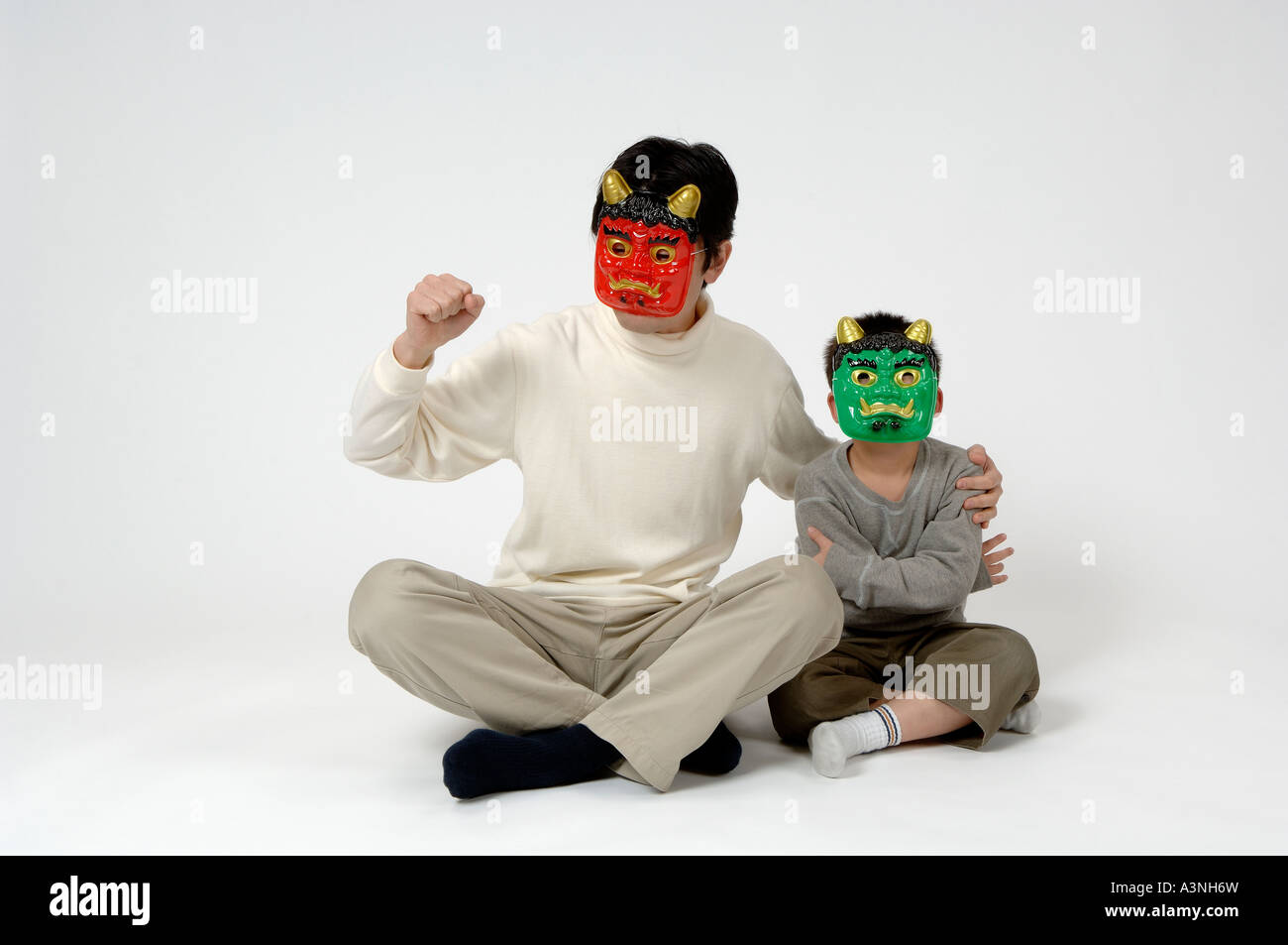 Father and son wearing mask of evil Stock Photo - Alamy