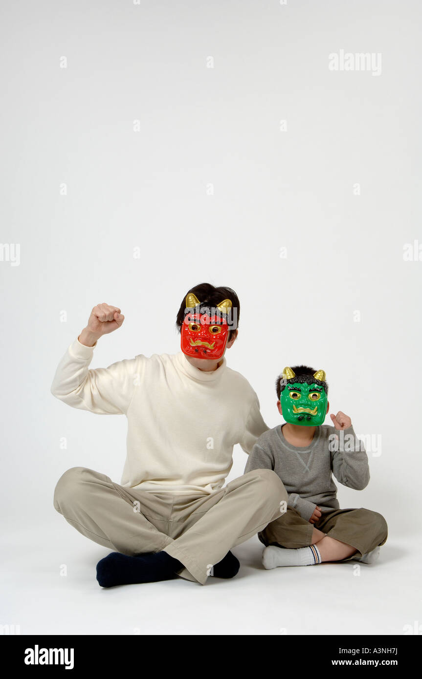 Father and son wearing mask of evil Stock Photo - Alamy