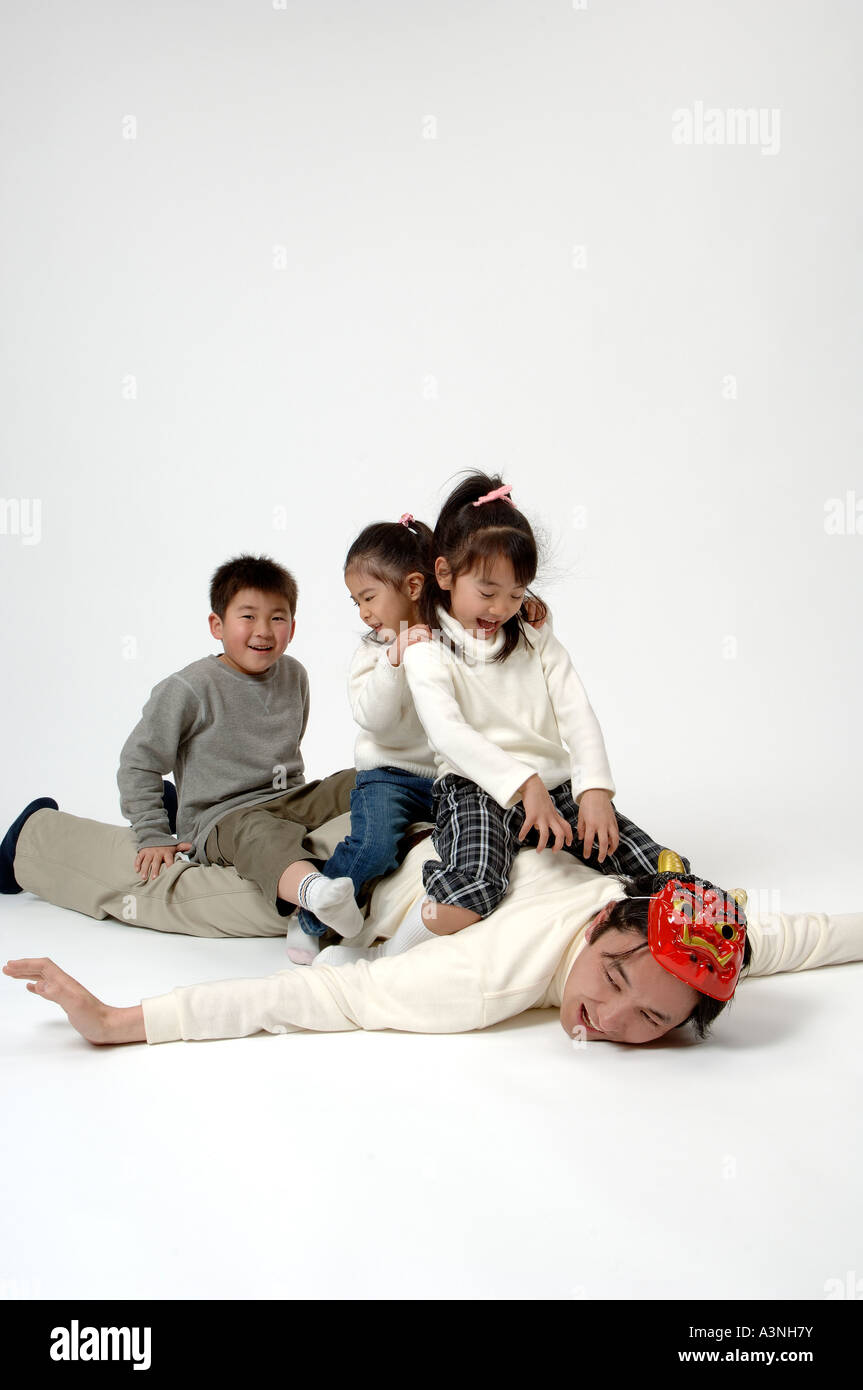 Children sitting on back of father Stock Photo - Alamy