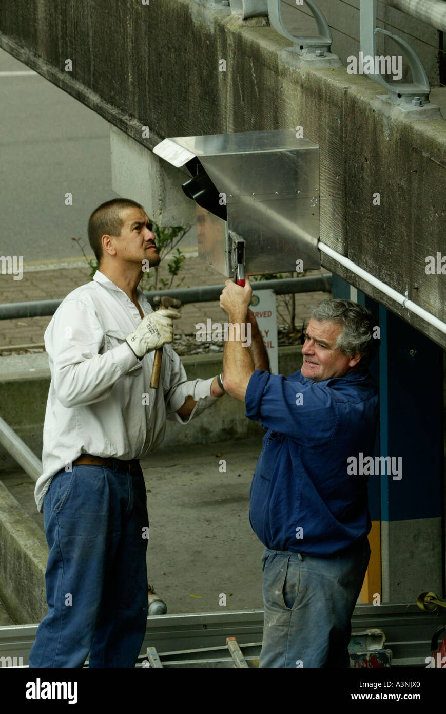 Workmen install security camera Stock Photo - Alamy