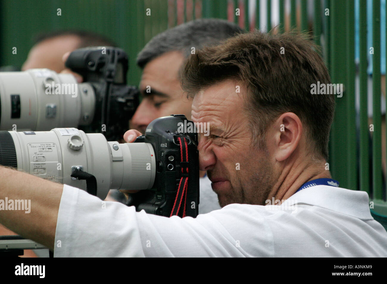 Sport photographers at tennis match taking a photograph Stock Photo - Alamy