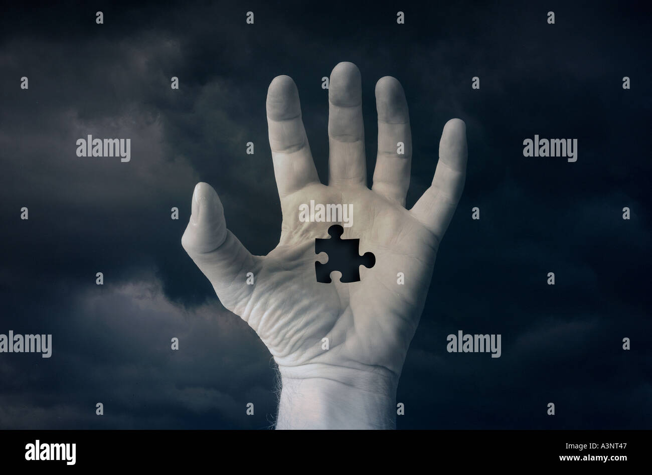 Hand with puzzle piece missing and clouds Stock Photo - Alamy
