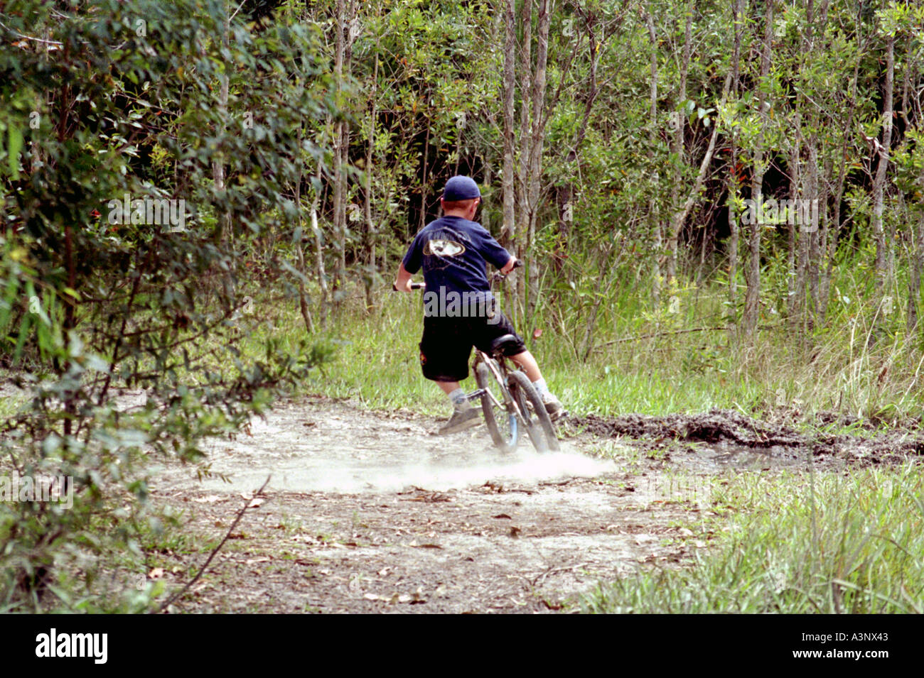 A YOUNG BOY RIDING HIS BICYCLE THROUGH THE BUSH Stock Photo - Alamy