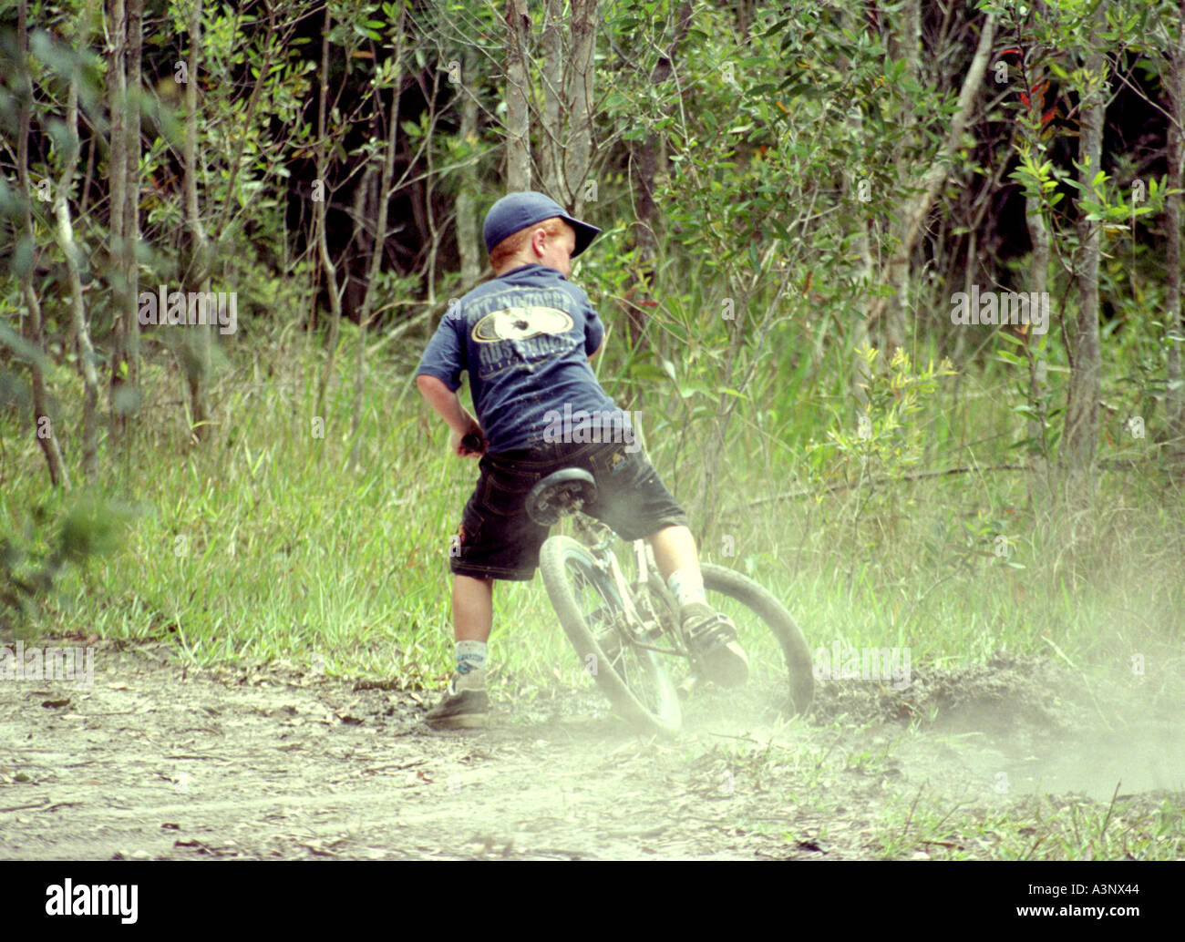 A YOUNG BOY RIDING HIS BICYCLE THROUGH THE BUSH Stock Photo - Alamy