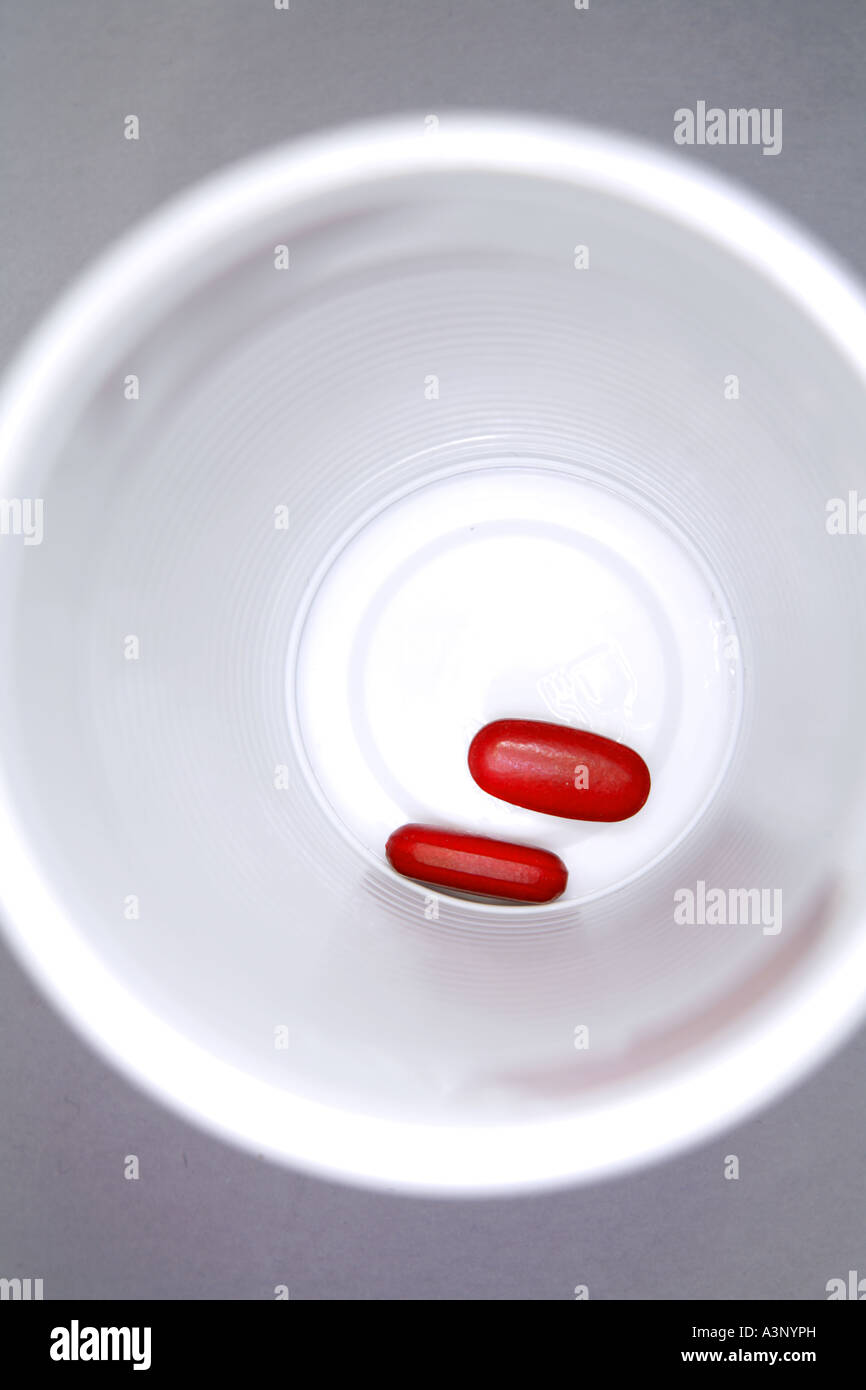 Two red tablets inside cup Stock Photo - Alamy