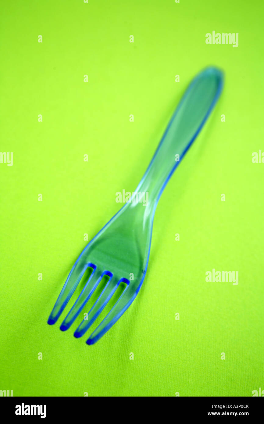 Plastic fork on green background Stock Photo - Alamy