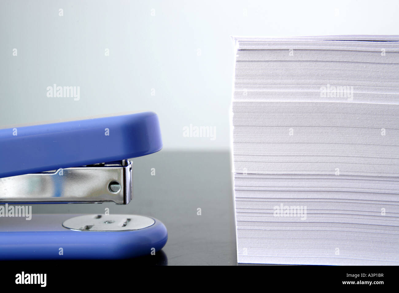 Stapler next to pile of papers Stock Photo - Alamy