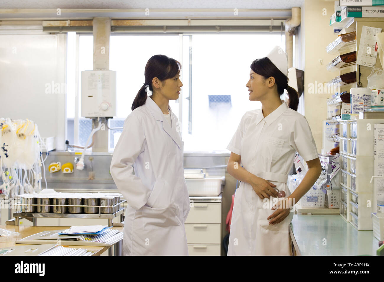 Female doctor and nurse talking Stock Photo - Alamy