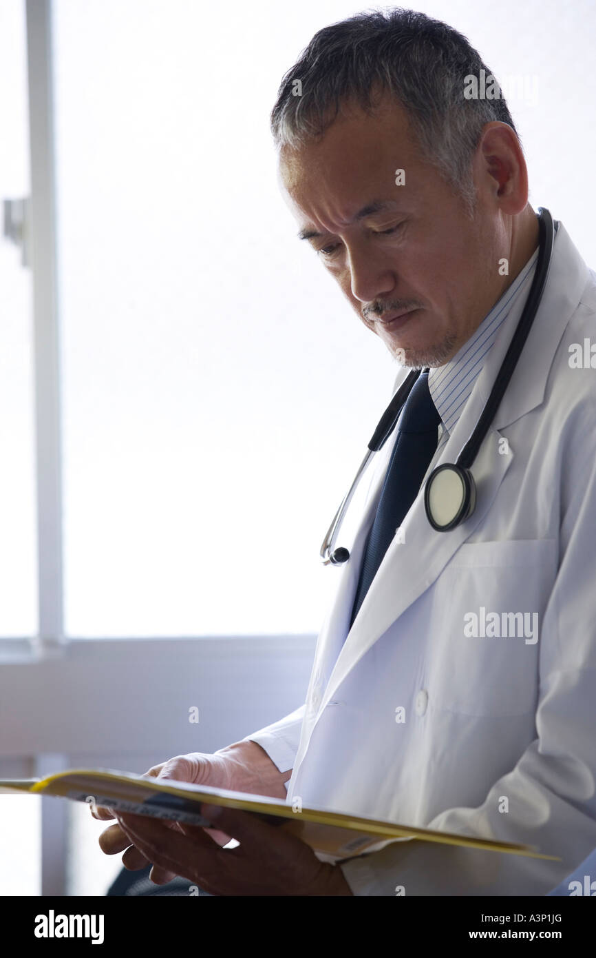 Doctor reading document Stock Photo - Alamy