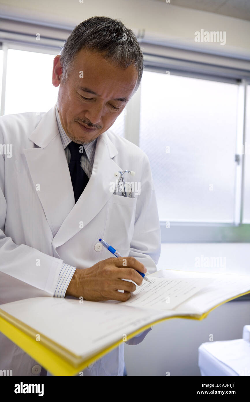 Doctor writing in chart Stock Photo - Alamy