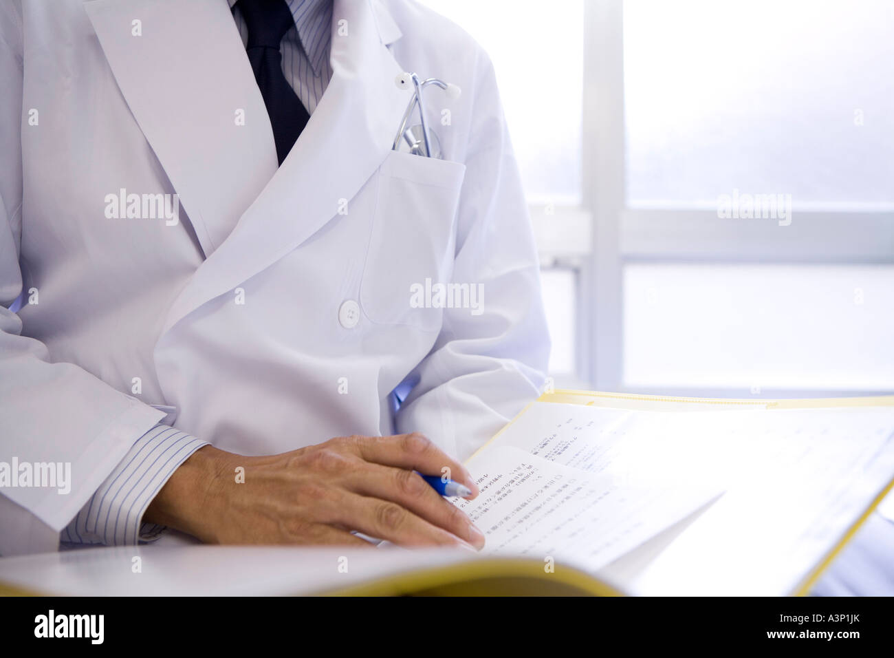 Doctor writing in chart Stock Photo - Alamy