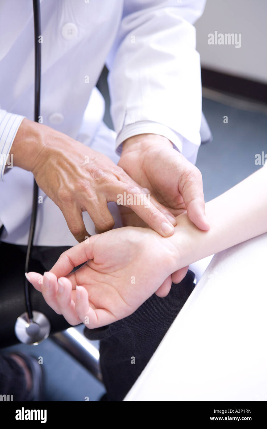 Doctor taking pulse of a patient Stock Photo - Alamy