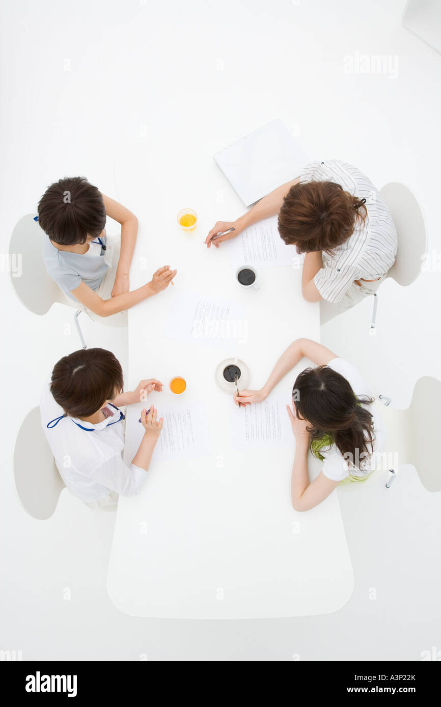 Four people meeting at table Stock Photo - Alamy