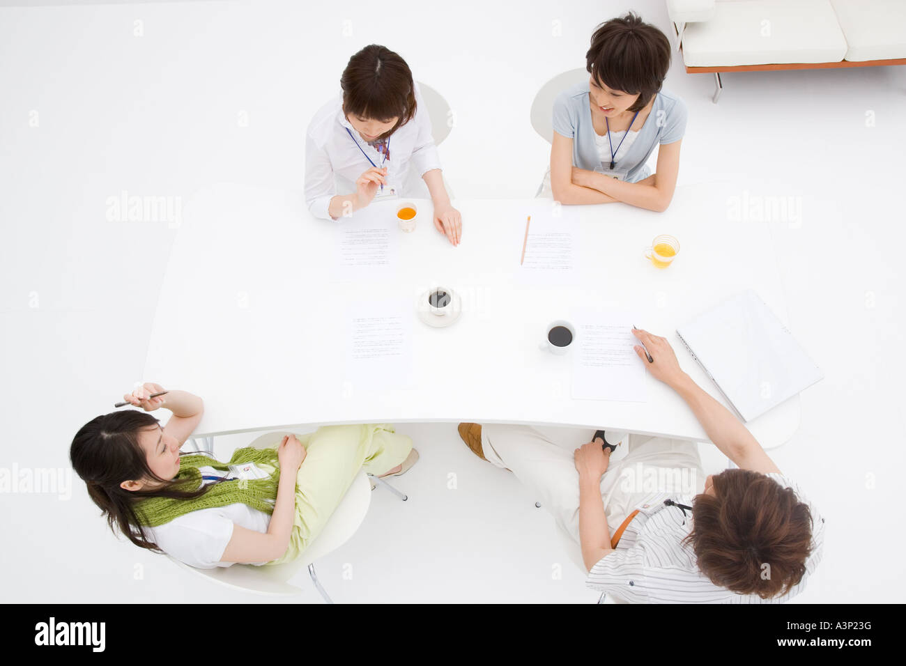 Four people meeting at table Stock Photo - Alamy