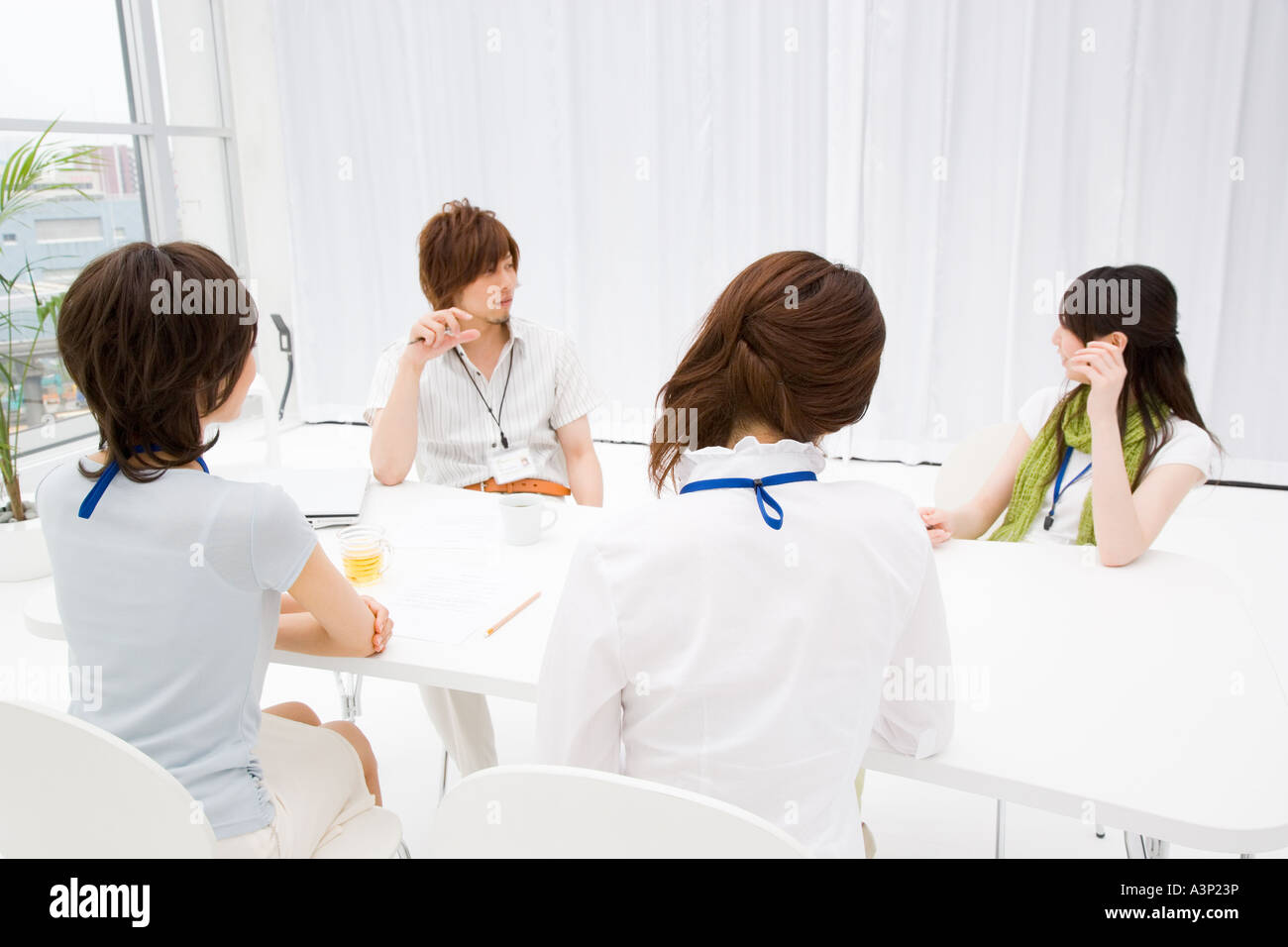 Four people meeting at table Stock Photo - Alamy