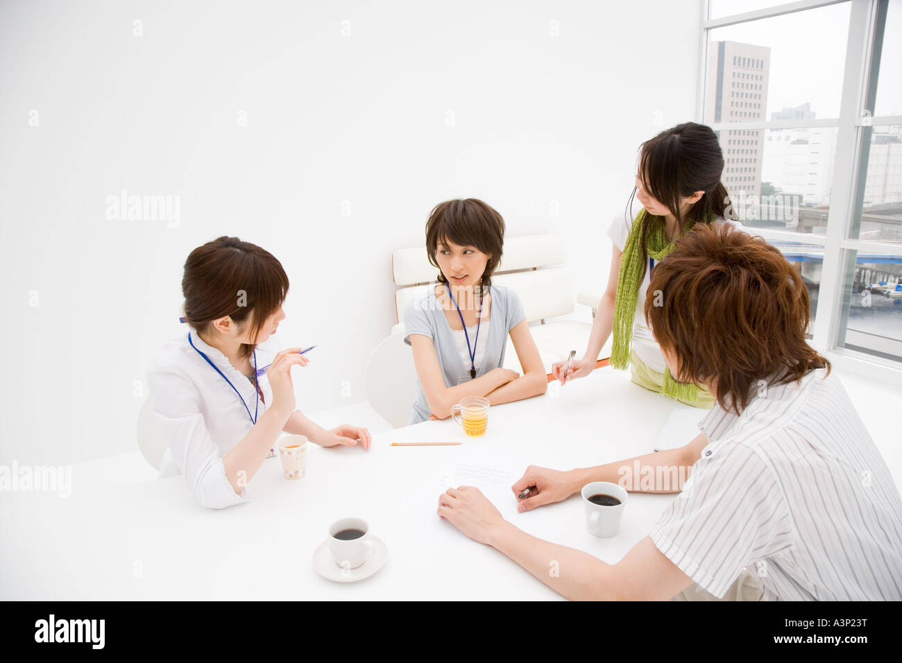 Four people meeting at table Stock Photo - Alamy