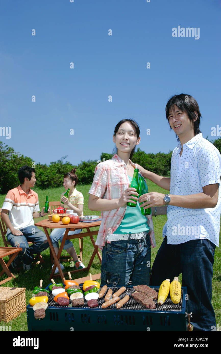 Four young people enjoying barbecue Stock Photo - Alamy