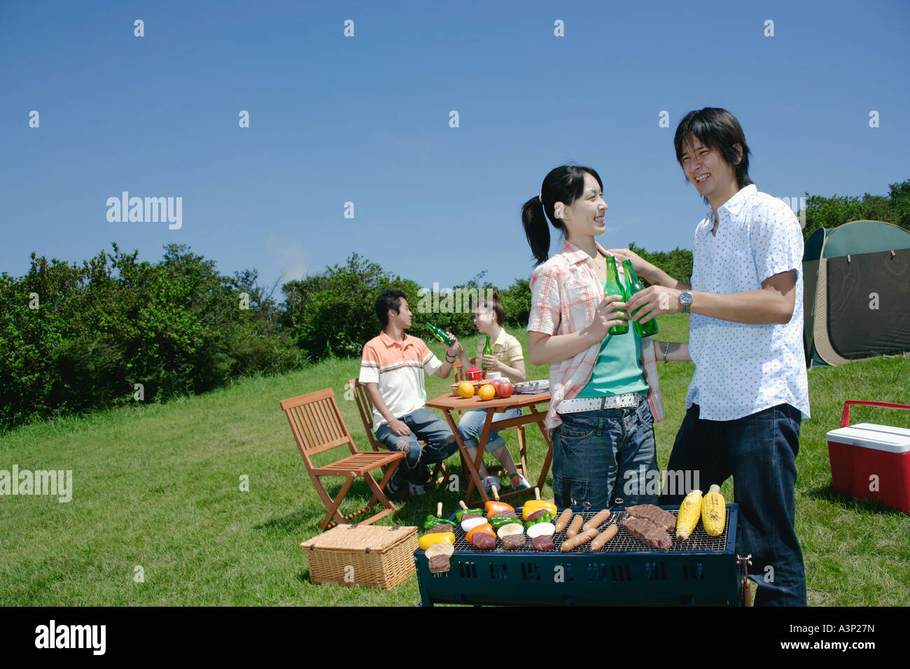 Four young people enjoying barbecue Stock Photo - Alamy