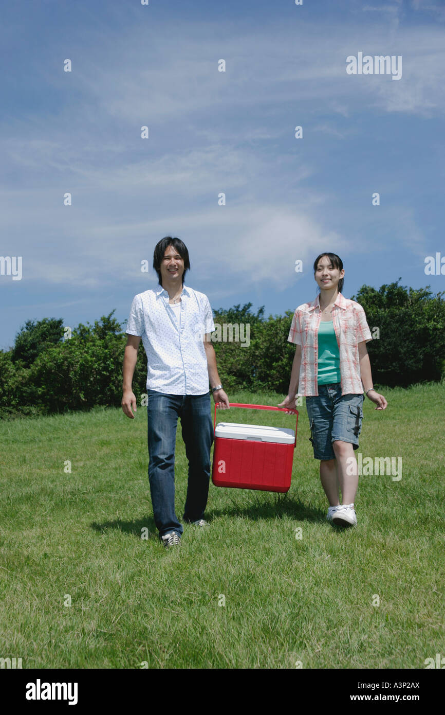 Young couple carrying cooler Stock Photo - Alamy