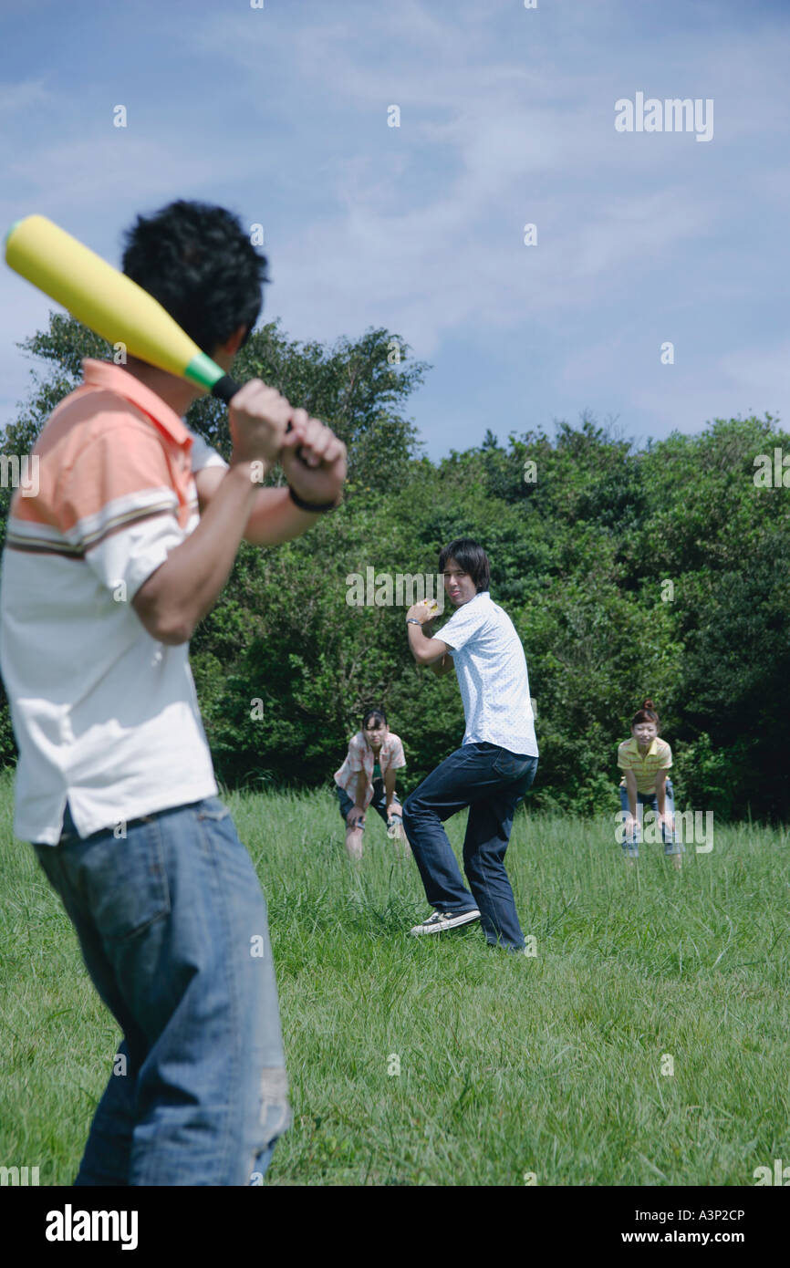 Four young people playing baseball Stock Photo - Alamy