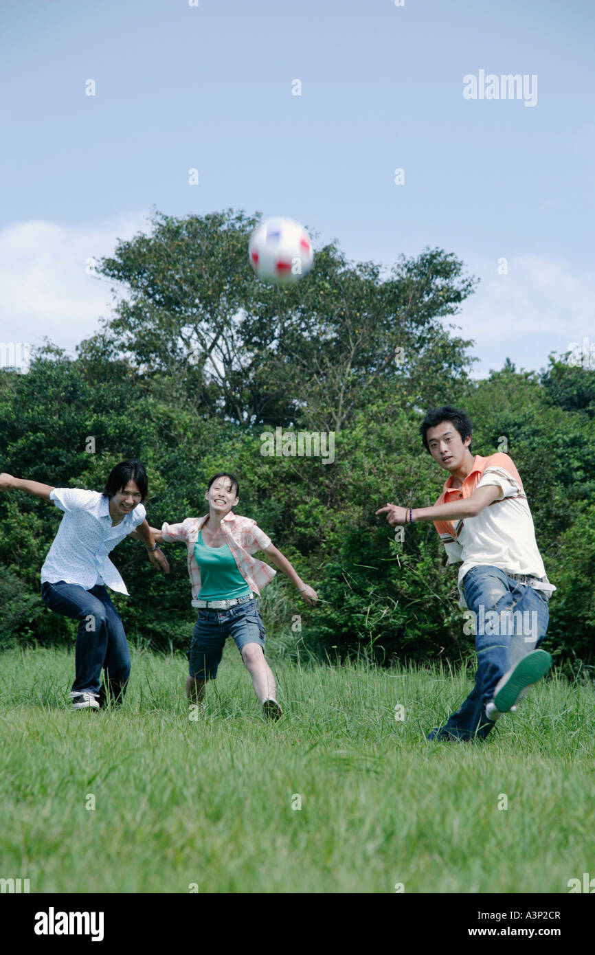 Three young people playing soccer Stock Photo - Alamy