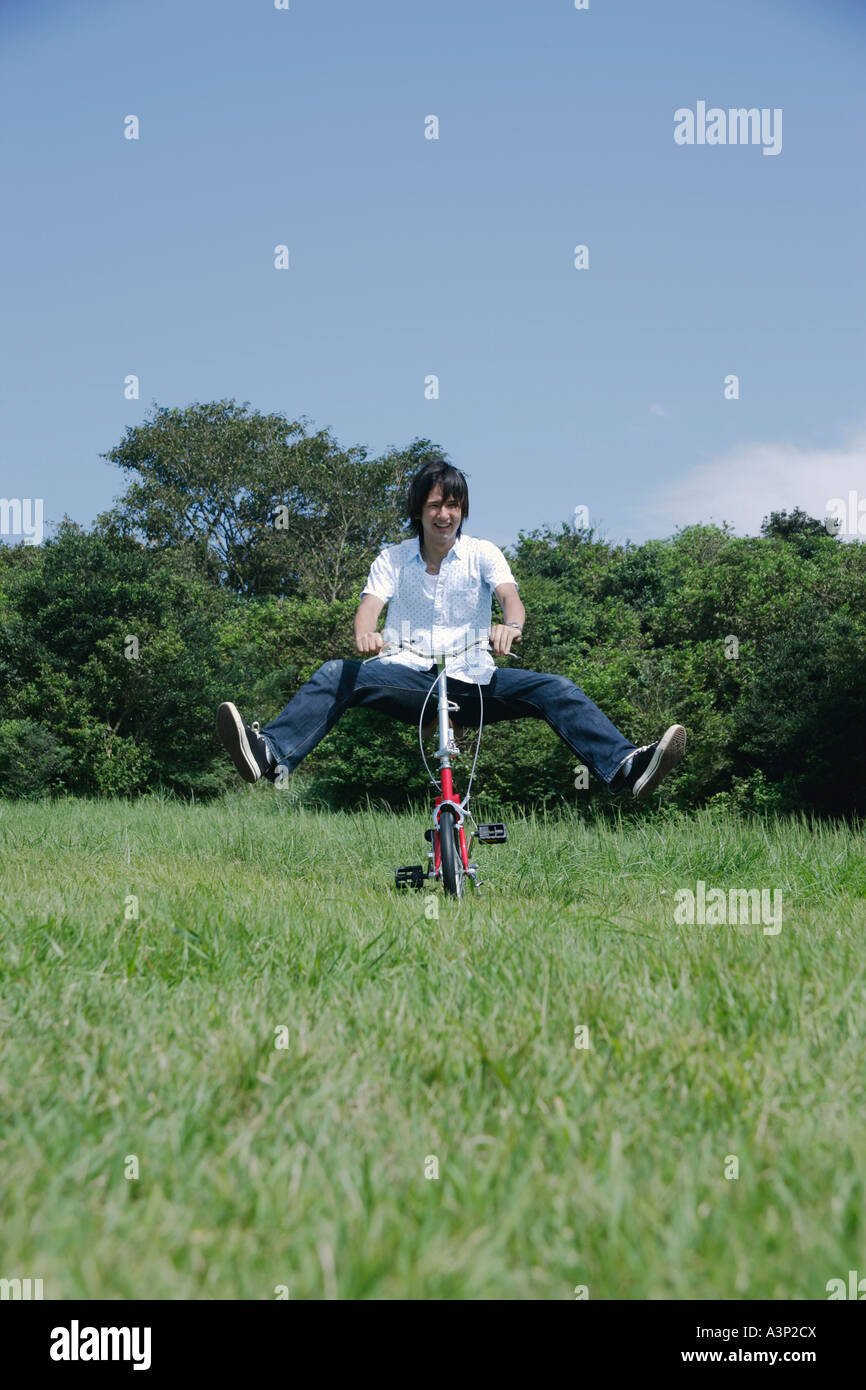 Young man riding on bicycle Stock Photo - Alamy