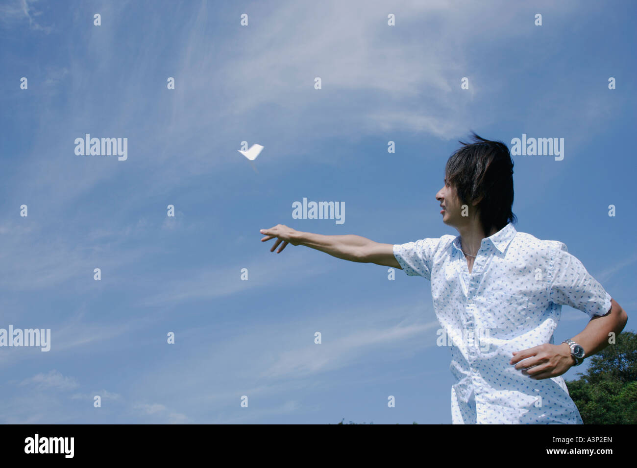 A young man flying paper airplane Stock Photo - Alamy