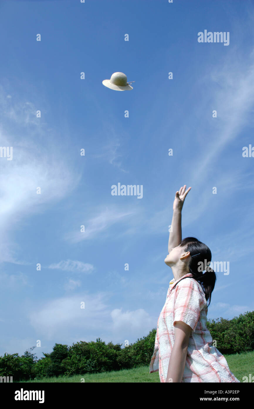 A young woman throwing a hat Stock Photo - Alamy